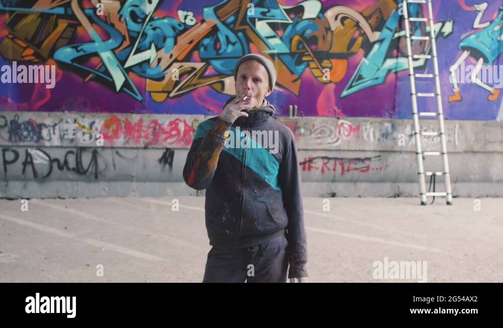 Graffiti artist smoking cigarette at graffiti background Stock Video ...