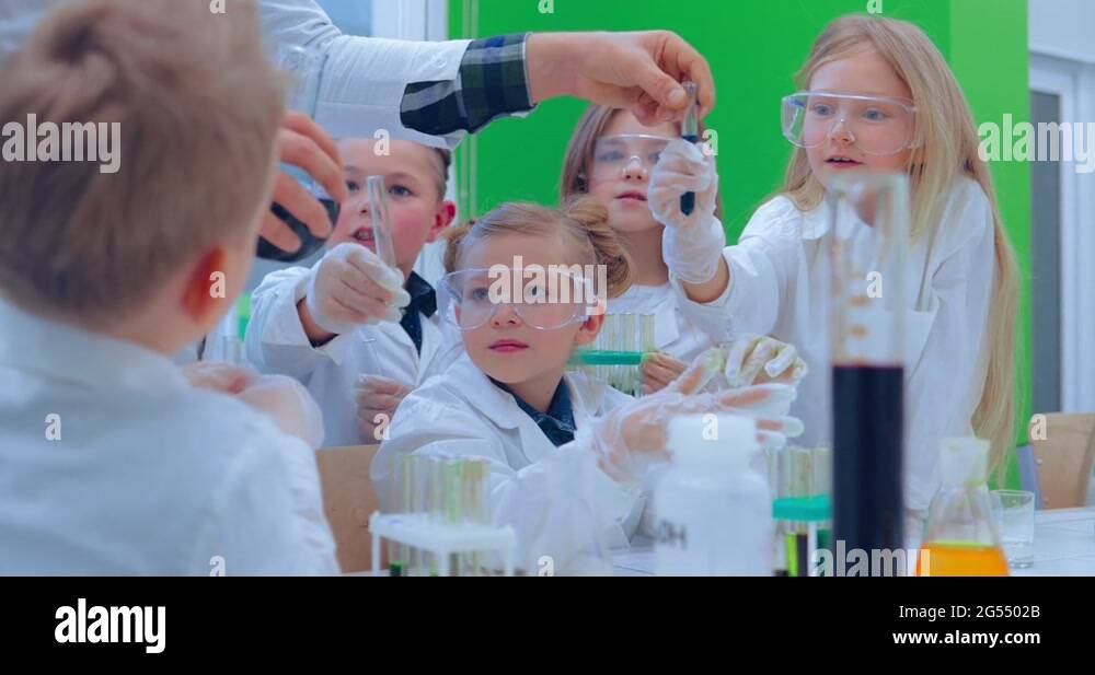 Teacher and students doing science experiment in school classroom ...