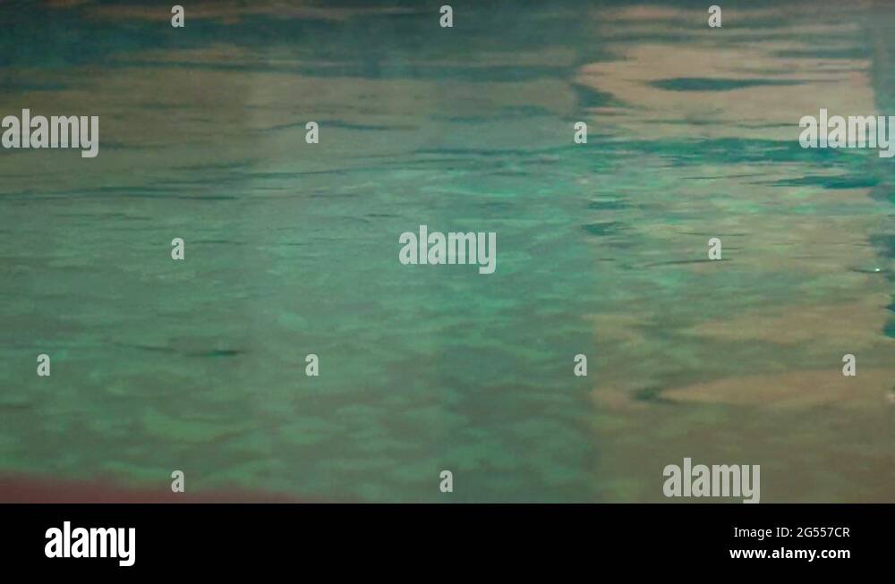 Swimming pool surface with reflection. Dark atmosphere background loop ...