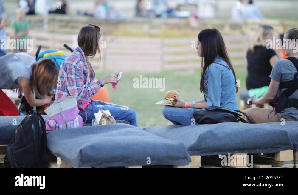 two beautiful girls eating burgers at the festival of street food Stock ...