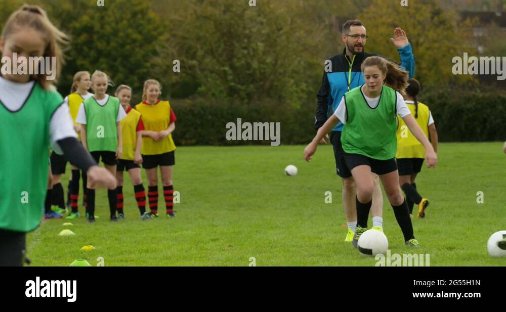 4K Young female soccer players training with the coach at football ...