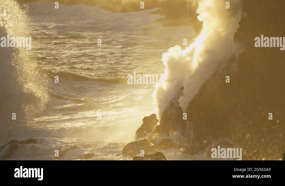 Red hot lava falling into ocean at sunset causing rising steam seen ...