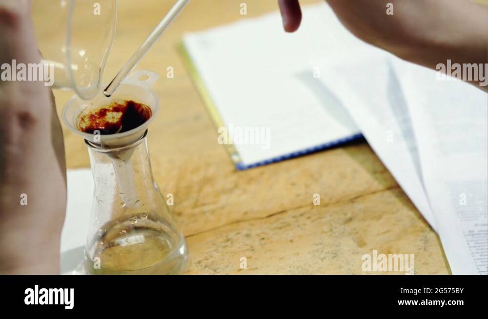 Scientist dropping the reagent into test tube for reaction testing in ...