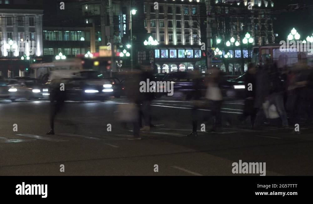 Anonymous people walking at pedestrians crossing crosswalk in the night ...