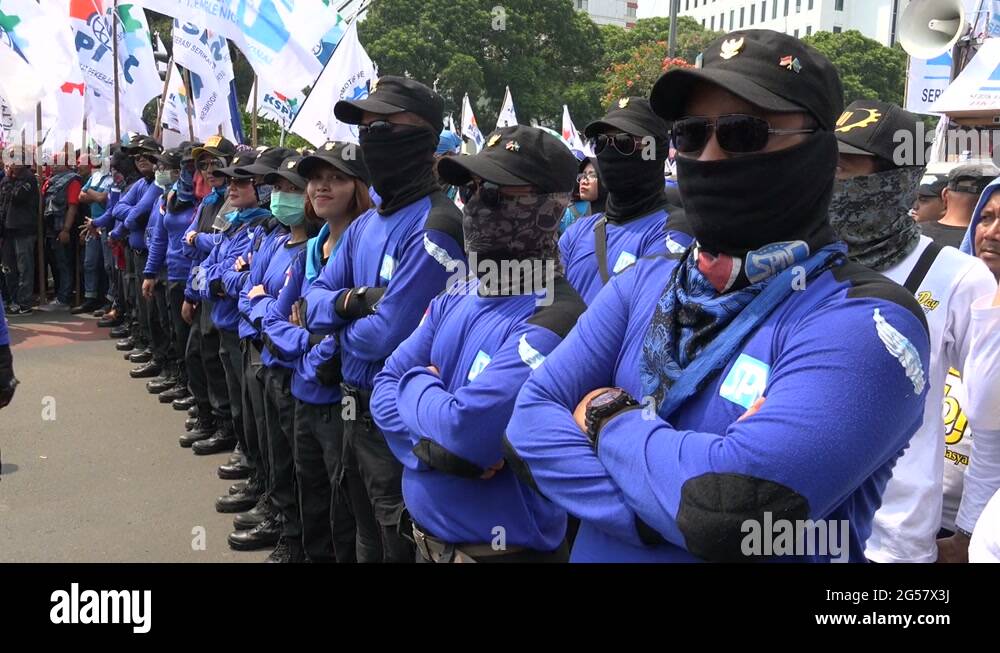 Asian voluntary security officers pose with crossed arms in Jakarta ...