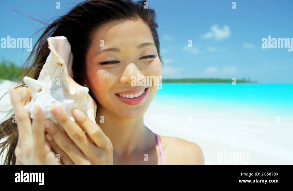 Asian Chinese girl holding conch shell at leisure resort Stock Video ...