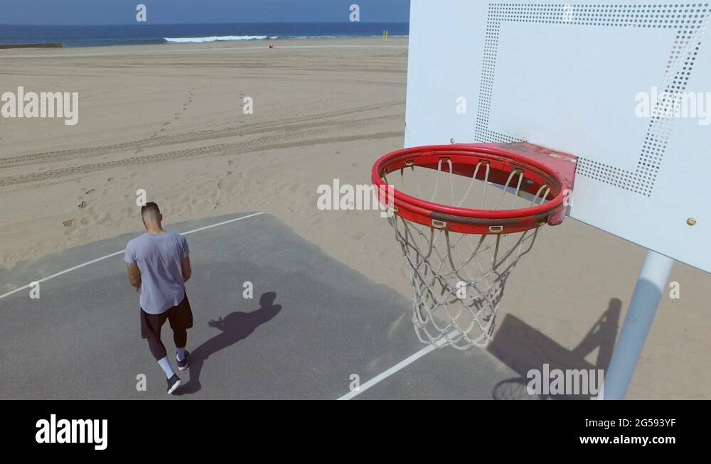Two men play one-on-one basketball hoops on a beach court Stock Video ...