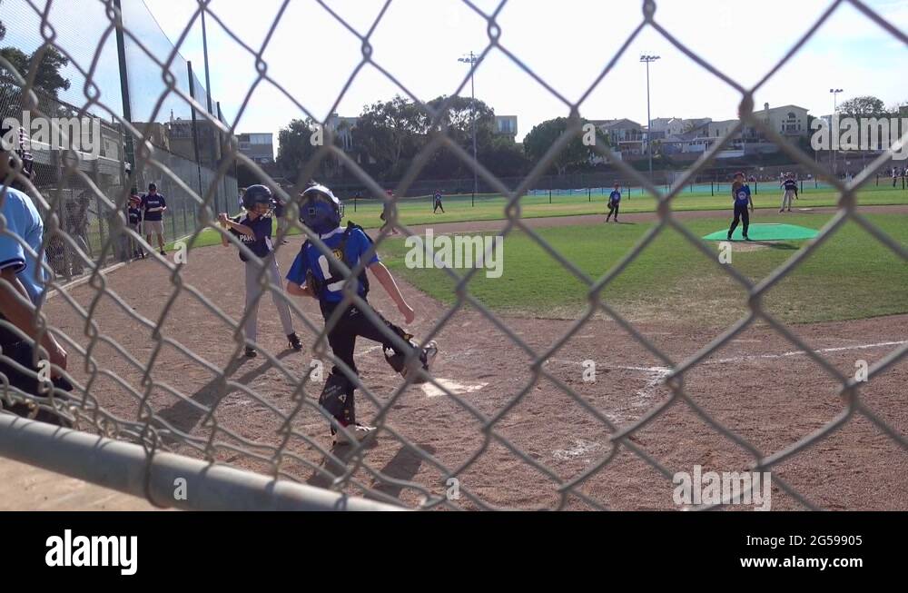 Boys playing in a little league baseball game through a chain-link ...