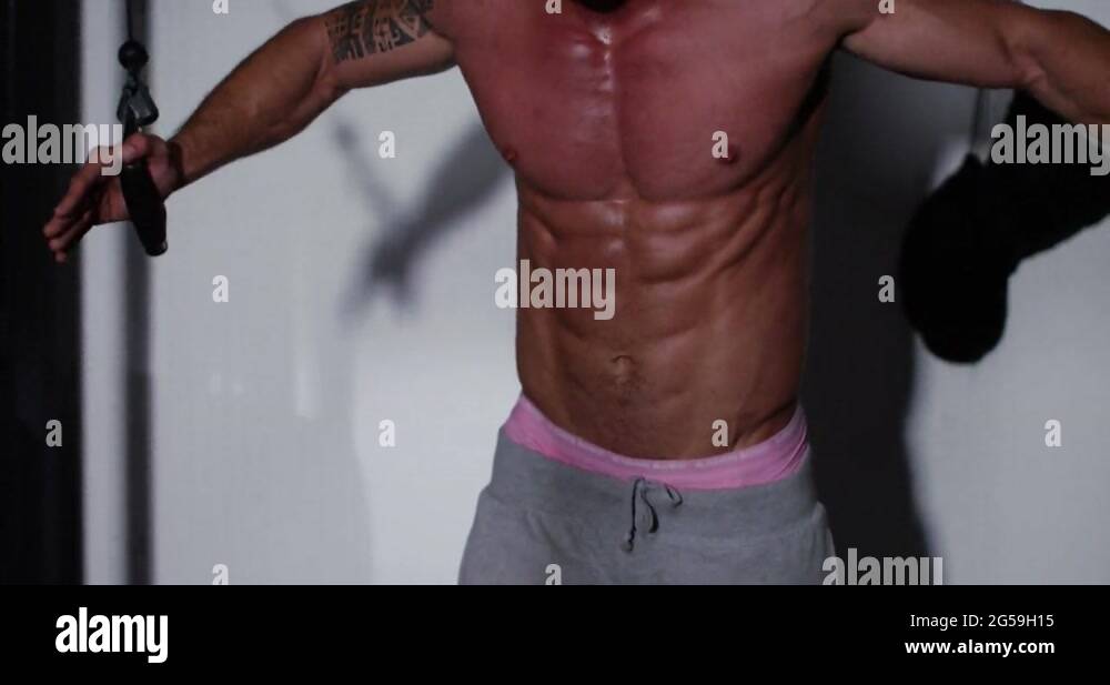 Athlete muscular bodybuilder training on a cable crossover fly pulley ...