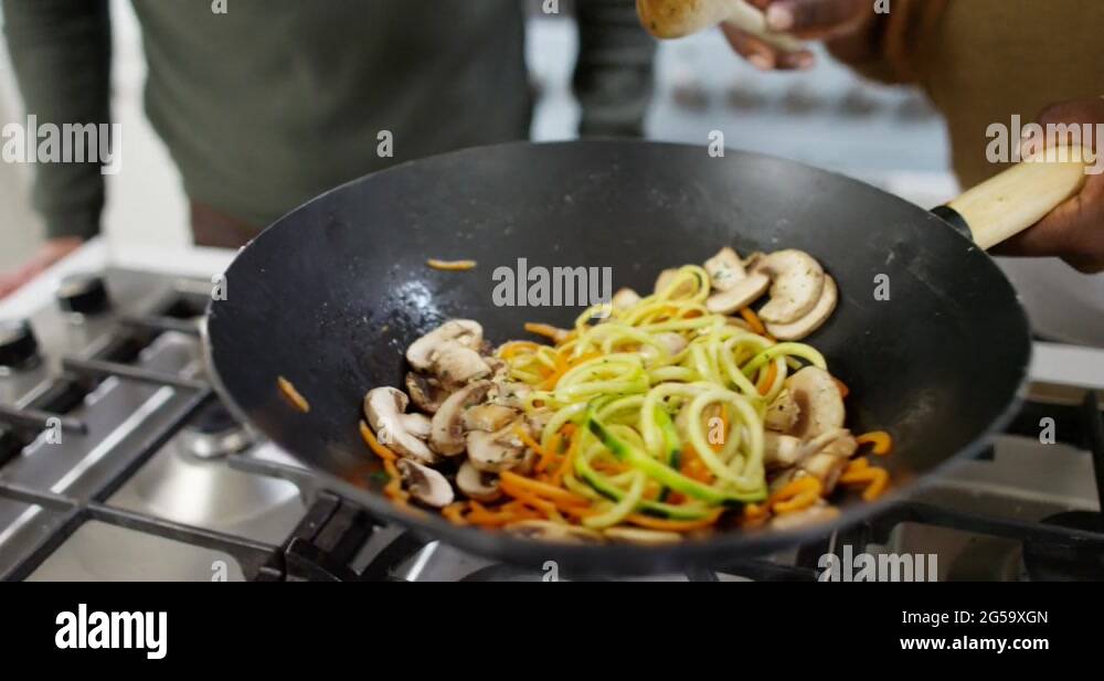 4K Happy extrovert TV presenters preparing a meal for modern TV cookery ...