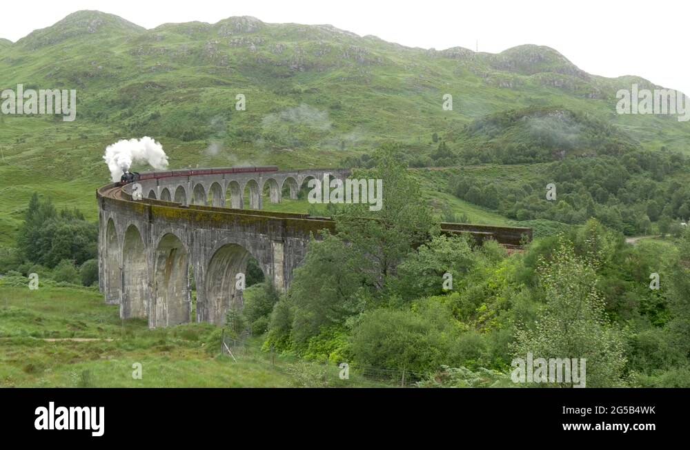 A steam train rolling on a railway bridge Stock Video Footage - Alamy