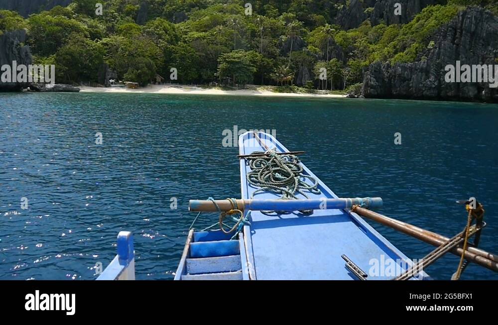 Traditional Philippine sailing ship coming into dock on sandy beach ...
