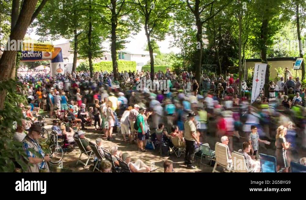 Spectators watching a crowd of people walking a the road, 4K time lapse ...