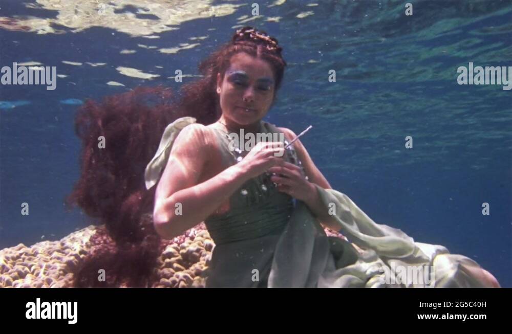 Underwater model free diver swims in clean transparent blue water in ...