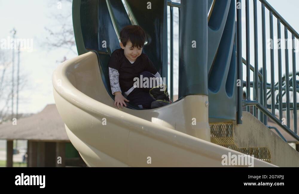 Boy slides down from top of spiral playground slide 4K Stock Video ...