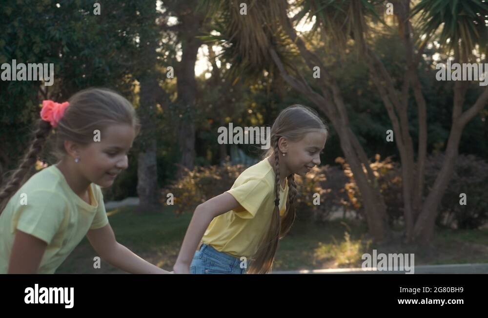 Little girls running in a hedge maze, two sisters kids hold hands and ...