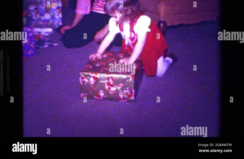 CALIFORNIA USA-1979: A Young Girl In A Red Dress Is Opening Presents On Stock Video Footage - Alamy