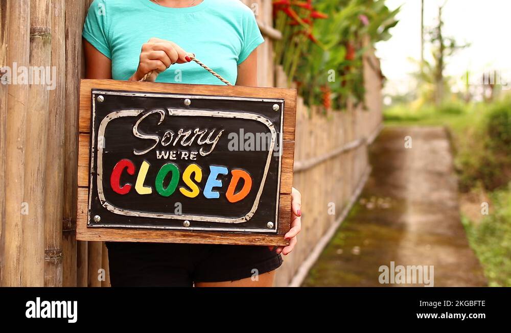Woman hands with closed sign board on a tropical nature background ...