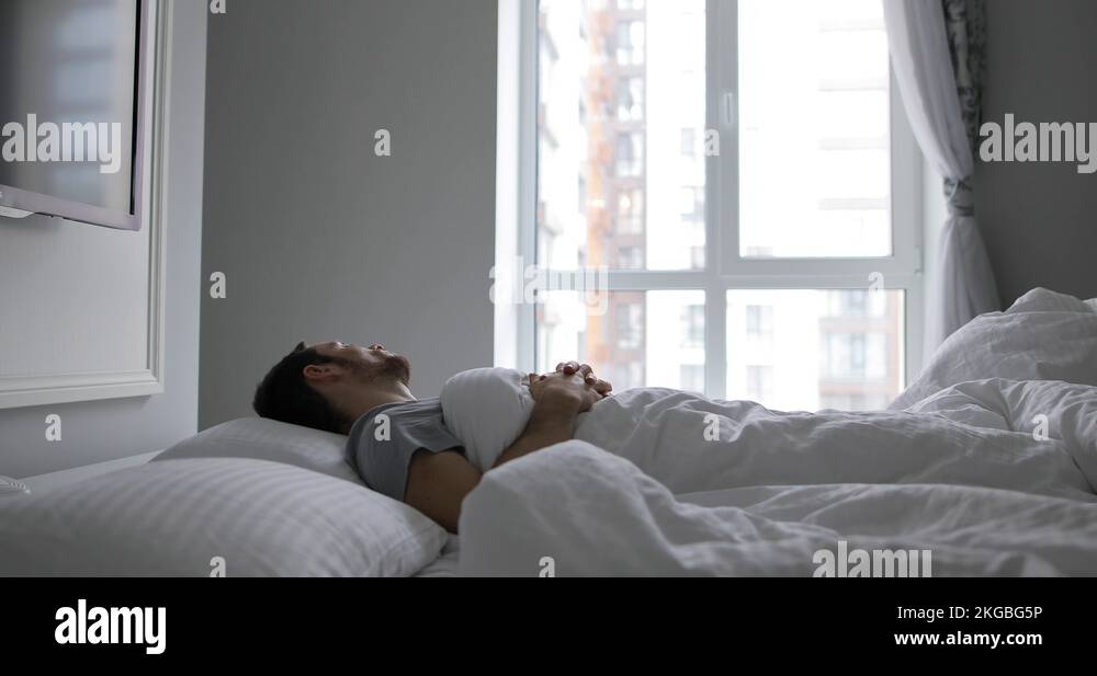 Man wake up in early morning on his bed, stretching arms Stock Video ...