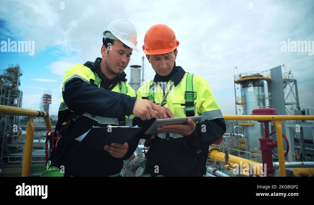 Two factory workman check and discussing working technology with paper ...