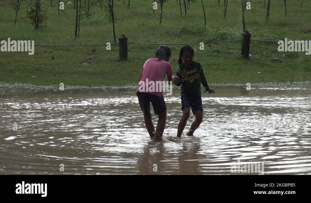 SIEM REAP, CAMBODIA : CHILDREN PLAYING in HEAVY RAIN Stock Video ...