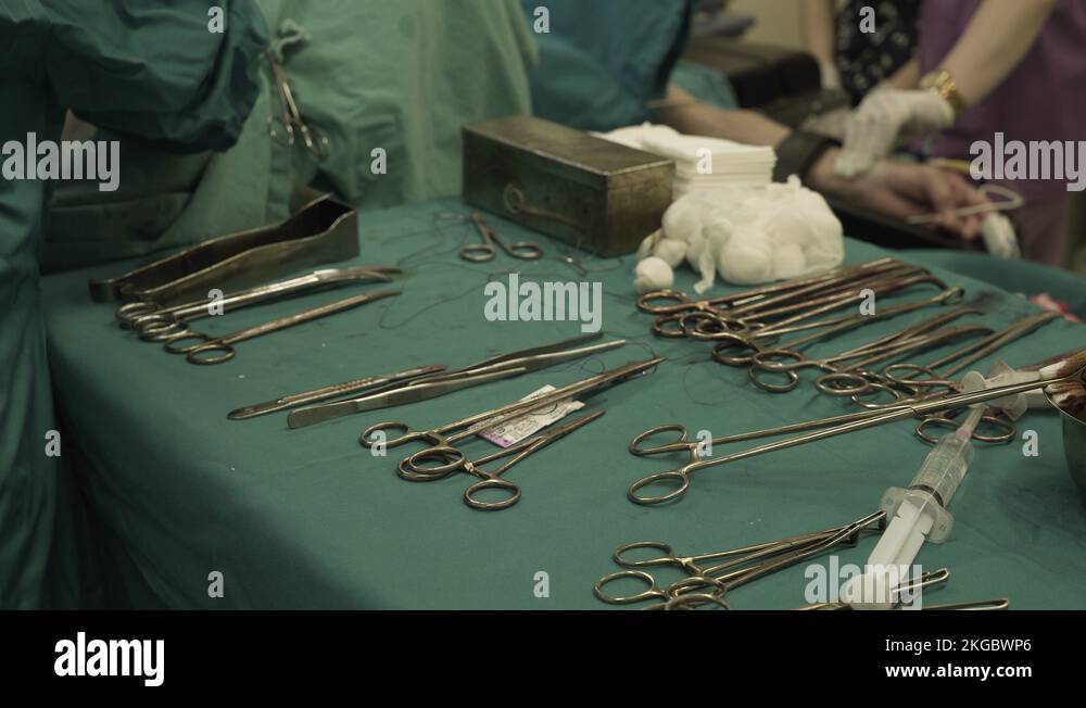 Nurse hands in surgical gloves adding instruments and tools from tray ...