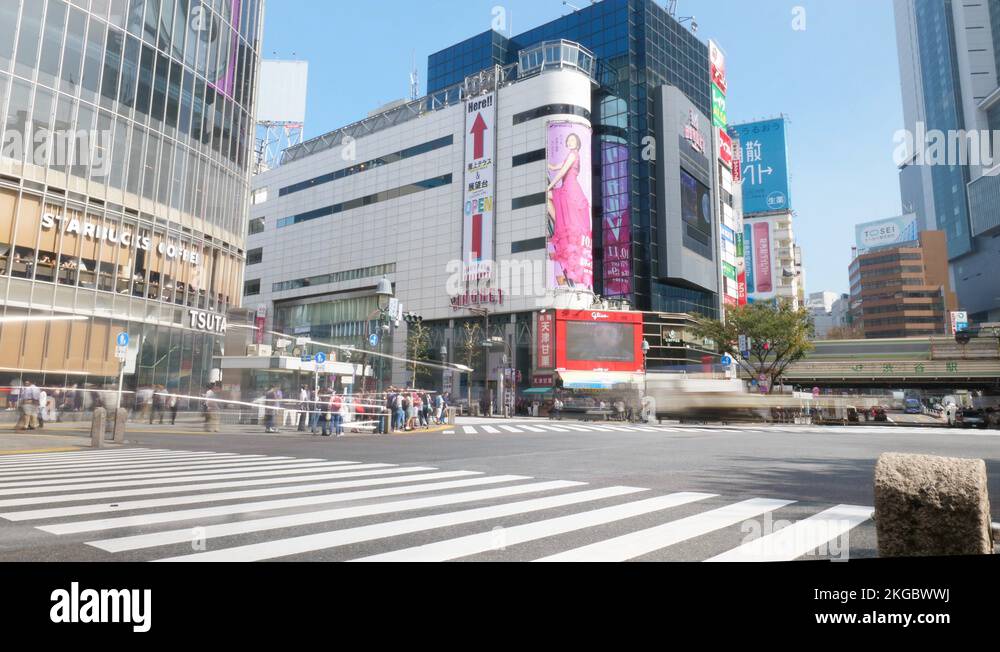People and vehicles cross the famous Shibuya intersection in Tokyo in ...