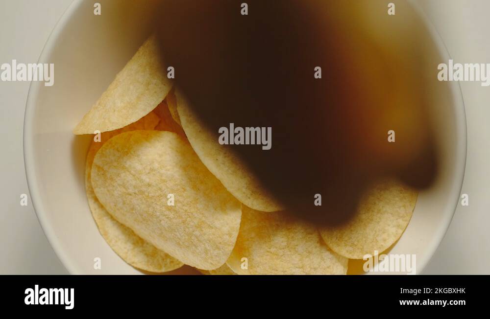 SLOW MOTION: Potato crisps falling into a white bowl - Top View Stock ...