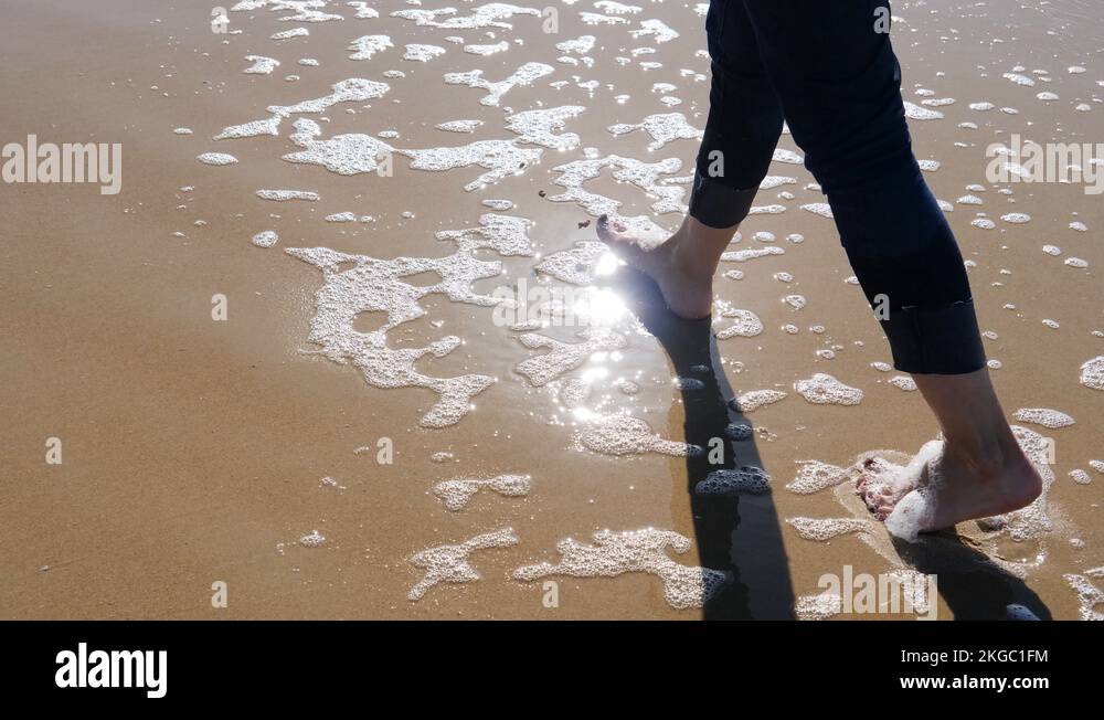 6 Barefoot female legs walking in shallow waterline in ocean waves ...