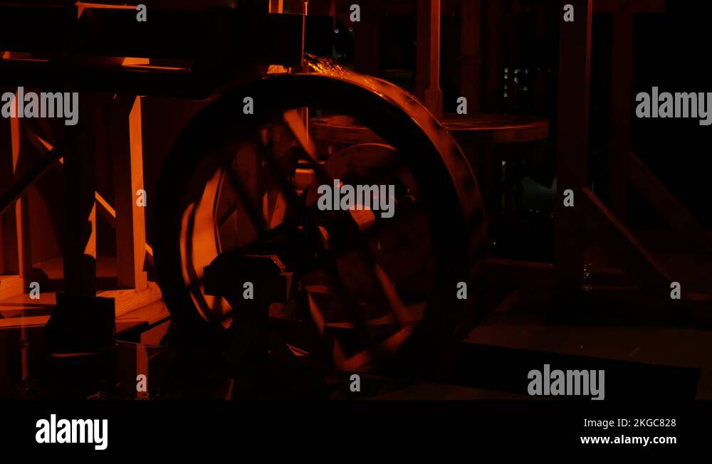 Water flow moving a wooden wheel of an old mill model in a dark ...