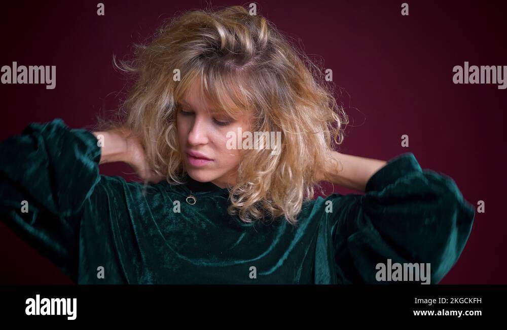 Closeup portrait of young stunning model tossing her blond hair and ...