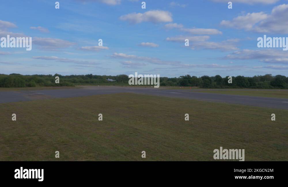 Small plane landing on a runway from an aerial perspective, drone ...