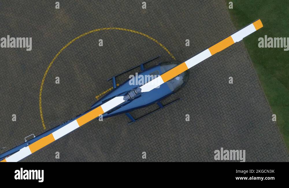 Stationary Helicopter on helipad, spinning top down perspective, drone ...