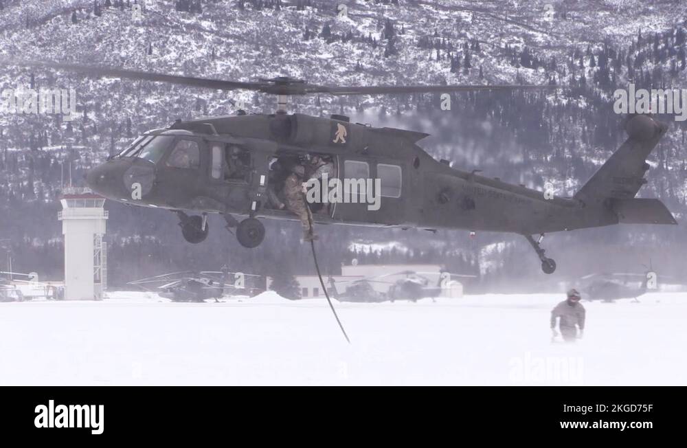 Soldiers fast roping from UH-60 Black Hawk onto snow in Alaska Stock ...