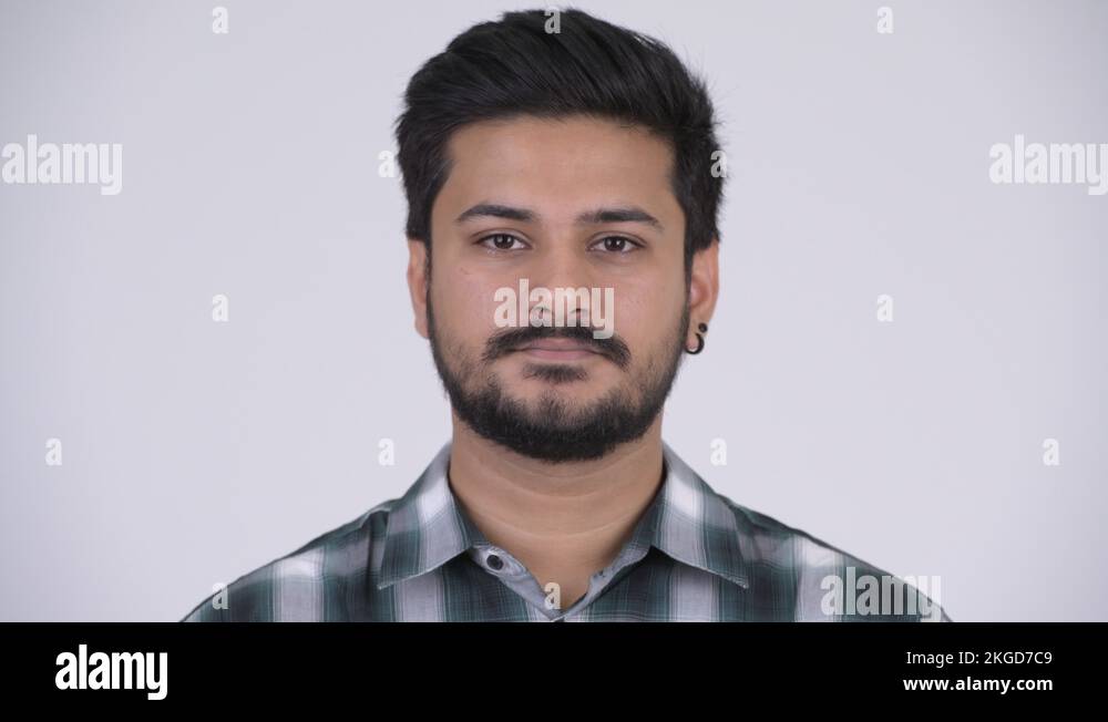 Young handsome bearded Indian man covering eyes as three wise monkeys ...