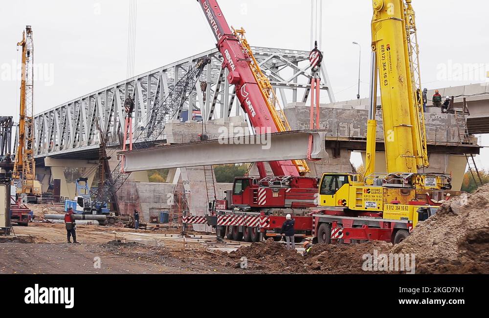 Massive bridge construction area where big concrete beam is lifted by ...