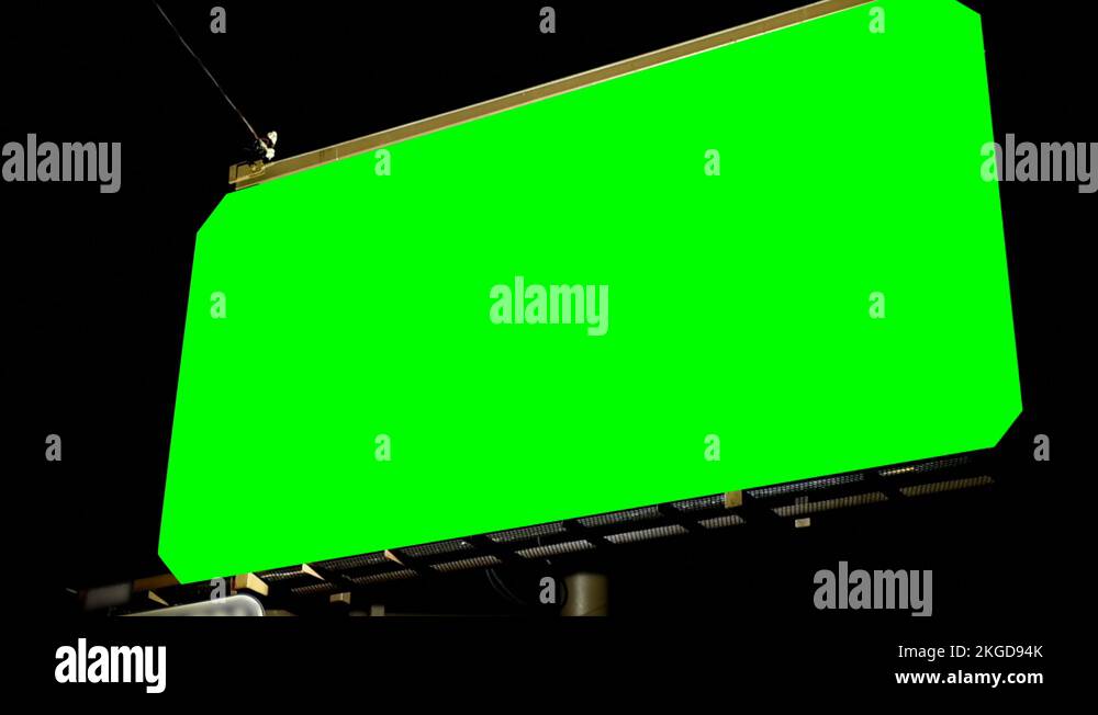 Low angle view of empty billboard with chroma key green screen at night ...