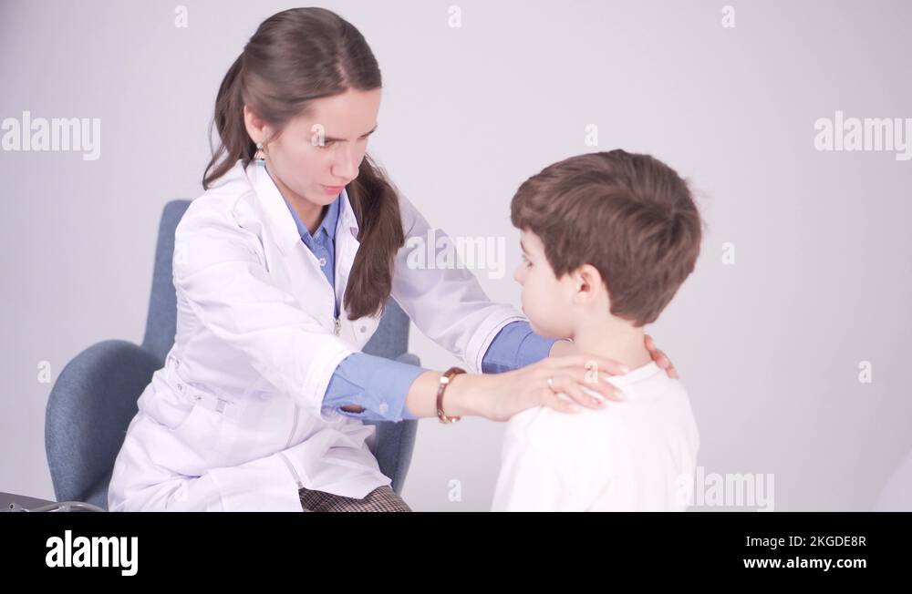 doctor is palpating lymph node on the neck of 7 years old boy, medical ...