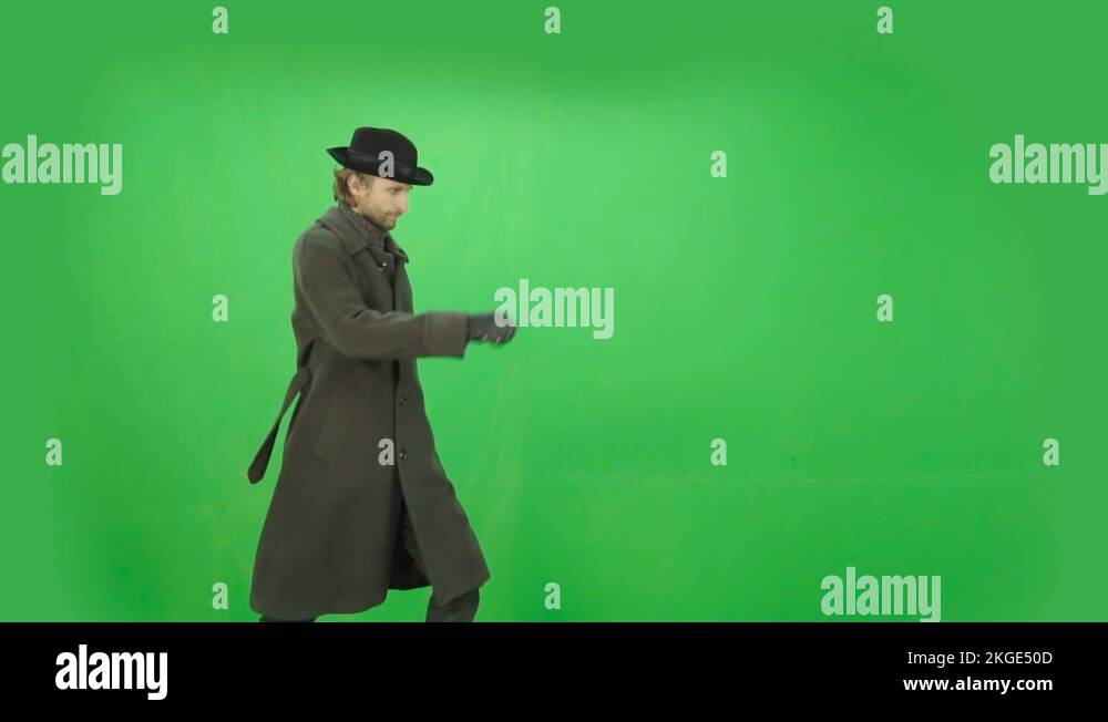 Brutal detective fights by legs and fists with hat and long coat green ...