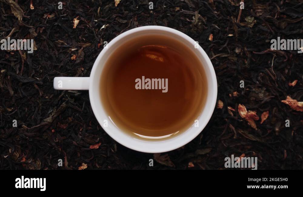 Loopable Cinemagraph of Cup of Black Tea among Dry Tea Leaves. Top View ...