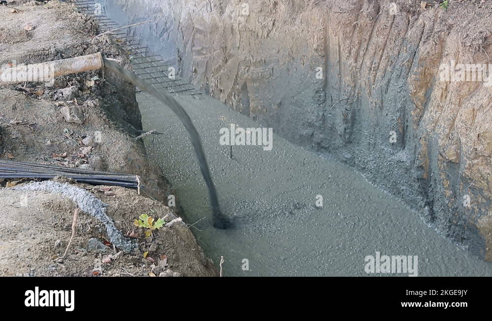 Pouring concrete mix into formwork. Formation of the foundation of the ...