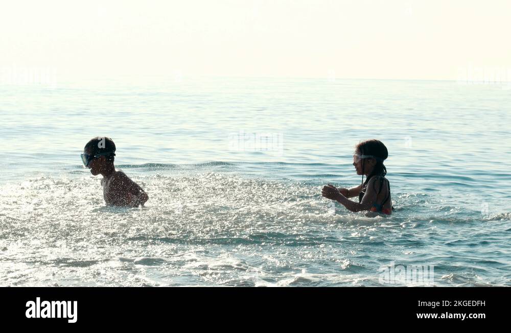 Children learn to swim in sea. Boys and girls swim and dive into sea ...
