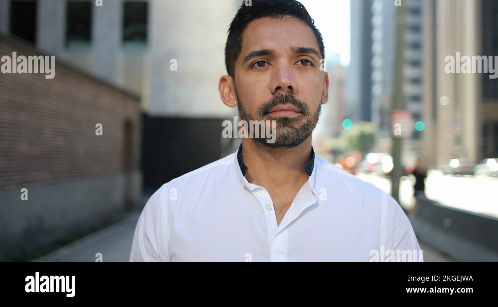 Young Latino Hispanic man in city walking street slow motion serious ...