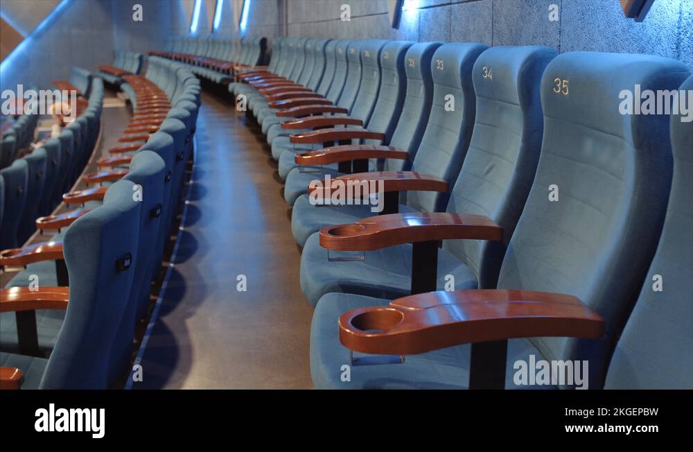 Close view of cinema seats in rows in empty hall. Camera is sowly ...