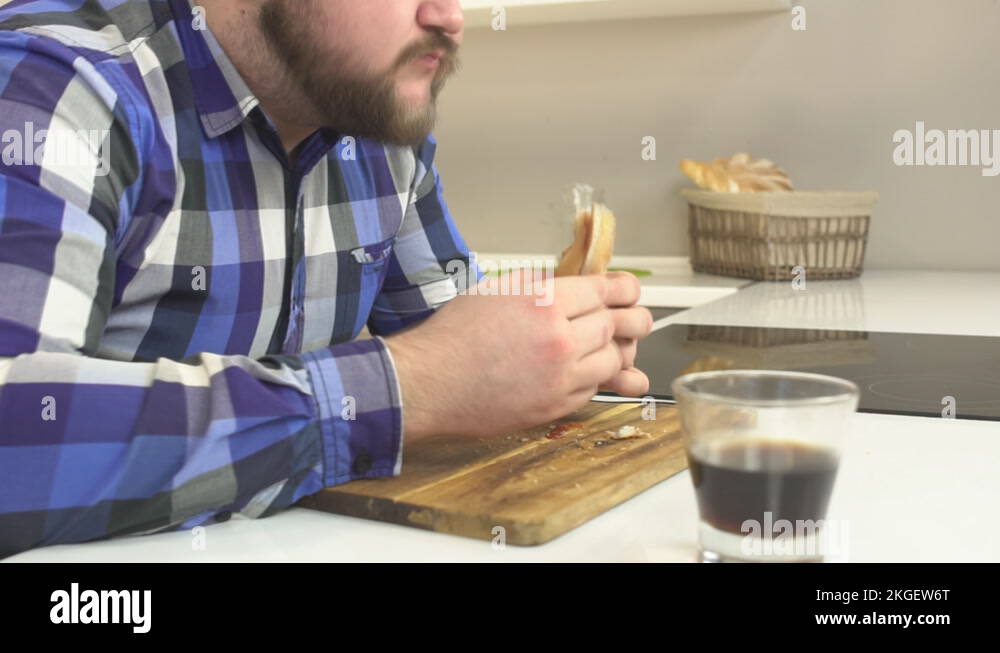 Fat man with a beard gorges on hamburgers and junk food, junk food ...