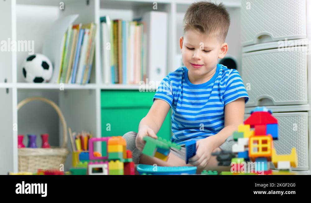 A creative boy is making a toy with a plastic building kit Stock Video ...