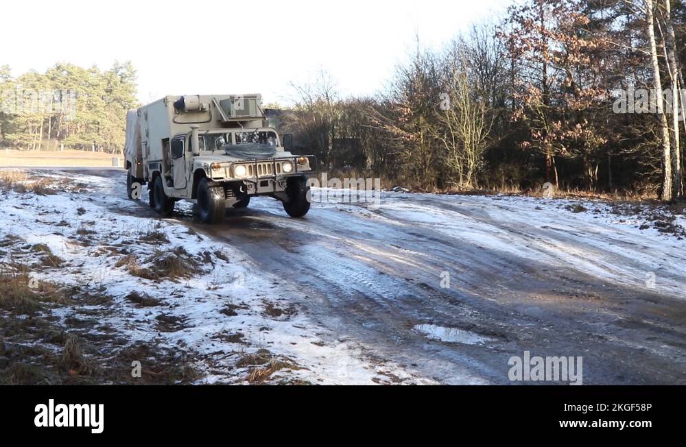 U.S. military Humvee jeep towing trailer driving over ice and snow ...