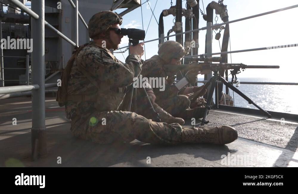 U.S. Marines looking through rangefinder and aiming rifle aboard USS ...
