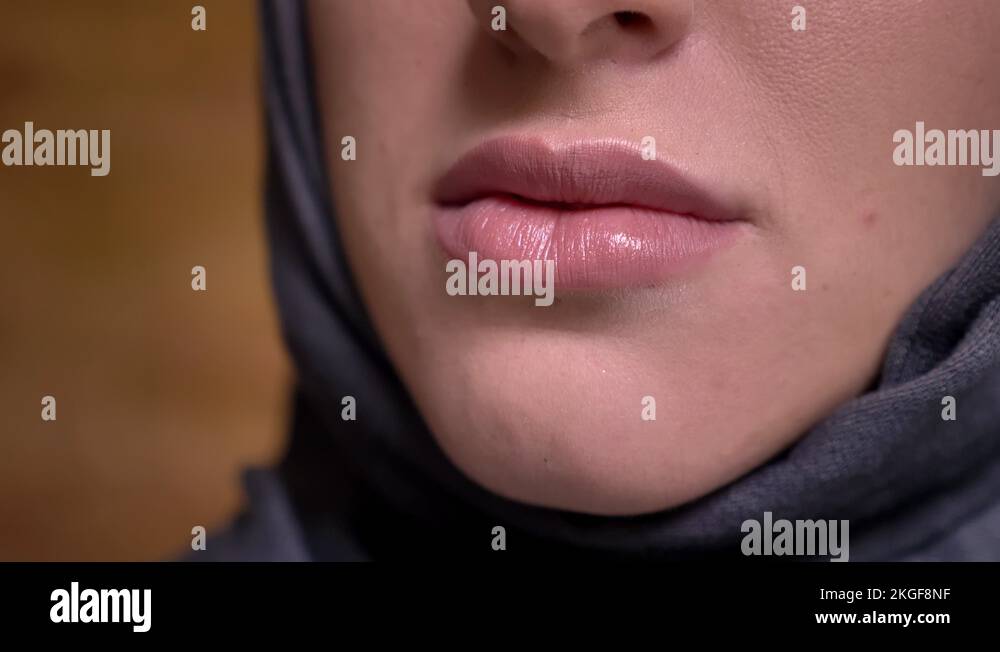 Close-up lip-portrait in profile of muslim woman in hijab smiling into ...