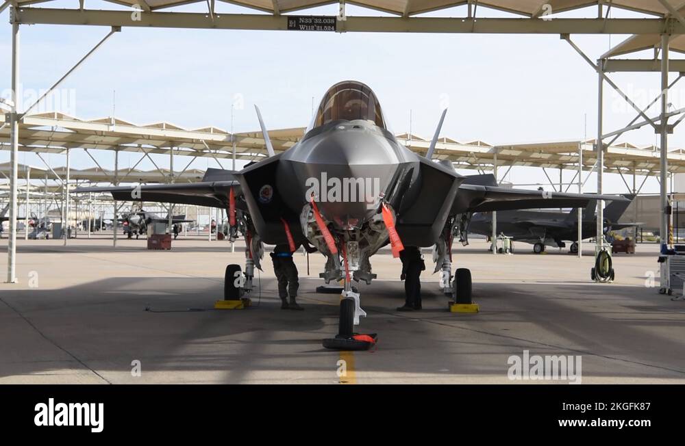 F-35C Lightning II parked beneath hangar with remove before flight tags ...